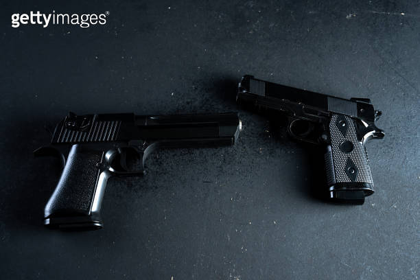Two guns on black table, criminal concept 이미지 (2154519551) - 게티이미지뱅크