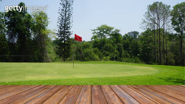 Wooden floor and golf course background. Fresh spring green golf course ...