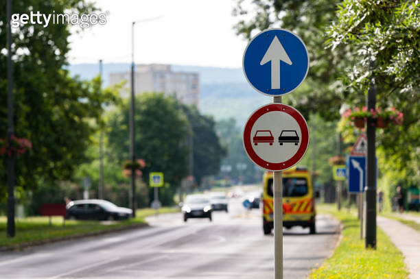 Direction to be followed and no overtake traffic signs with some cars ...