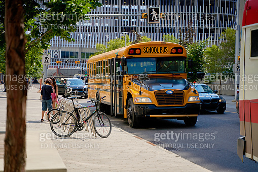 A yellow old school bus drives through the modern city of Calgary. 이미지 ...