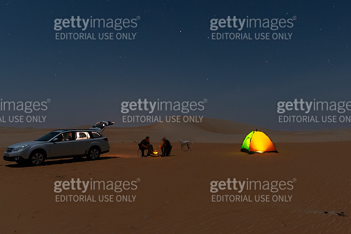 Friends enjoy Stars motion across night sky during off road camping in ...