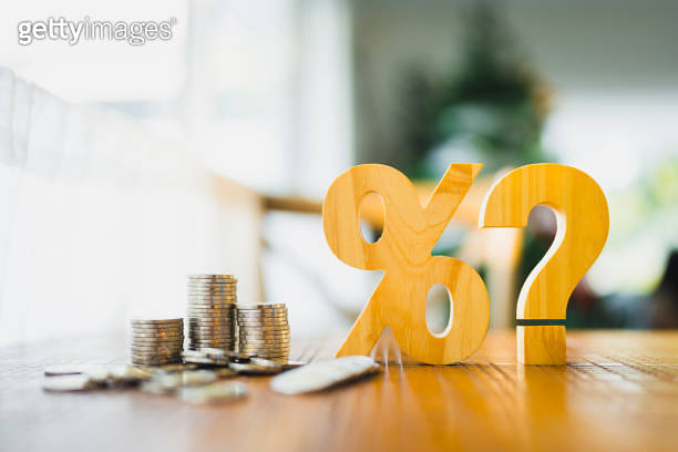 Percentage and question mark on wood table, raising or lowering Fed ...