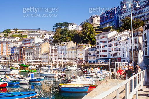 Luarca harbour. Multicolored fishing boats and townscape. Asturias ...