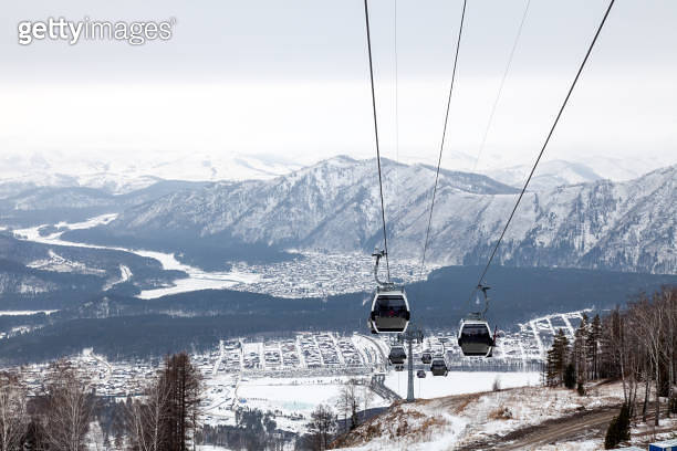Cabin of a gondola cableway suspended on a rope where sits people with ...