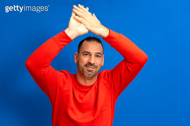 Hispanic man with beard in his 40s clapping with his hands above his ...