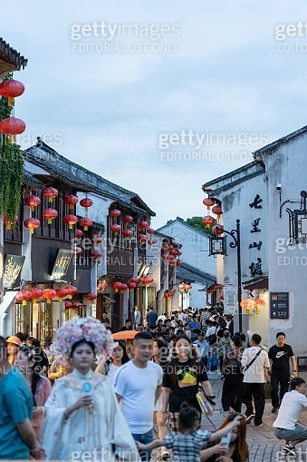 A bustling street in Suzhou, China, adorned with red lanterns, as ...