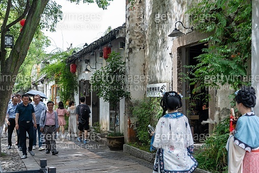 A narrow stone path in Suzhou, China, lined with traditional buildings ...