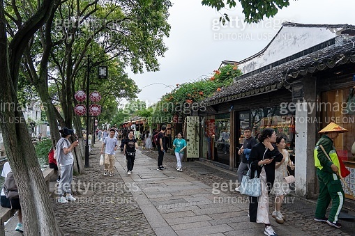 A cobblestone street lined with traditional Chinese buildings in Suzhou ...