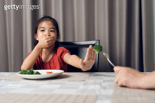 Little cute kid girl refusing to eat healthy vegetables. Children do ...
