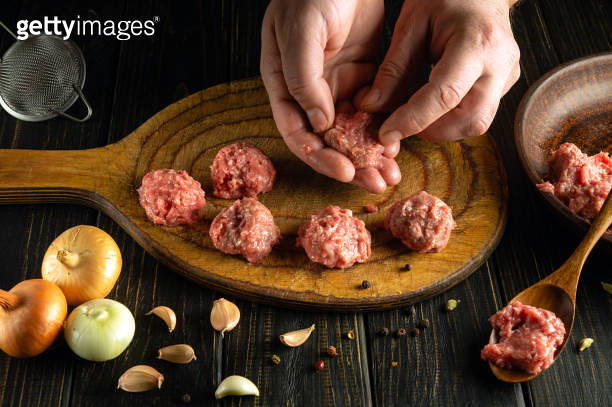 Chef shapes ground meat to make homemade meatballs for lunch. Concept ...