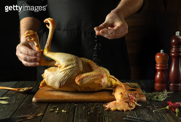 The chef is preparing a rooster on the kitchen table in a public house ...