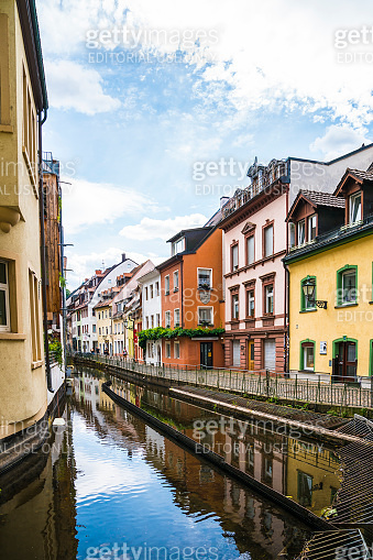 Colorful beautiful old town buildings next to river water in fischerau ...