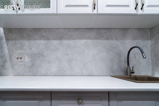 sink with tap in the kitchen with a decorative wall made of plaster in ...