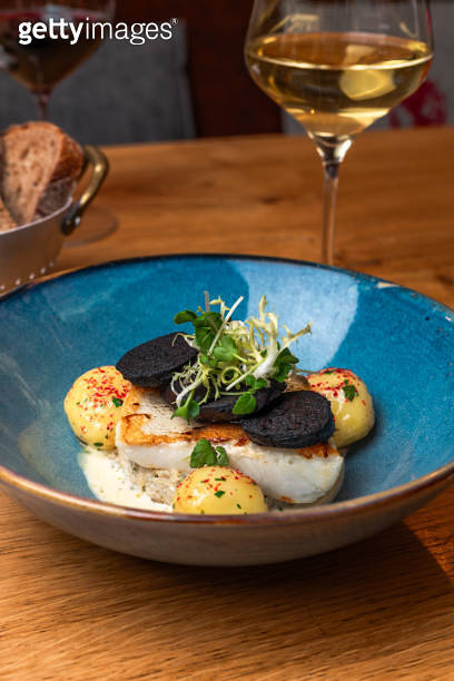 White fish fillet dish with potatoes foam sauce gravy sauce served in ...