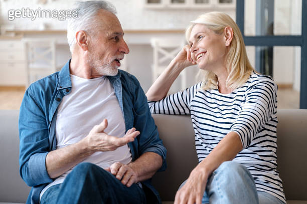 Emotional middle aged man talking with woman and sharing impressions of ...