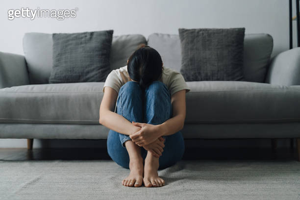Unhappy lonely depressed woman is sitting on the couch. She looks sad ...