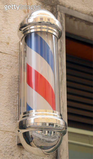 Barber shop s rotating striped pole sign with spiral design outside the ...