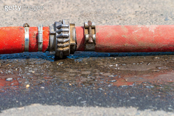 The red hose is laying on the ground. The hose is leaking 이미지 ...