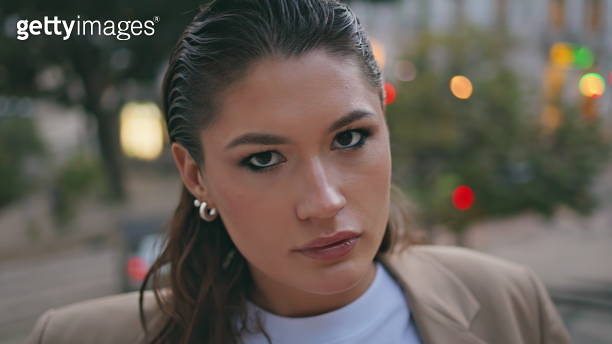 Sexy Brunette Looking Camera In Front Blurred Cityscape At Twilight