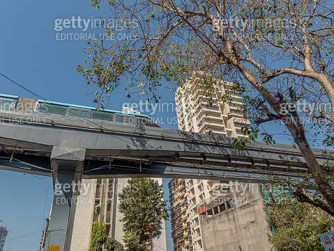 Tall multi-storied buildings behind the 30 feet high elevated mono-rail ...