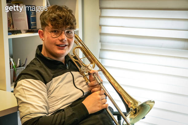 portrait of smiling boy with trombone 이미지 (2048255653) - 게티이미지뱅크