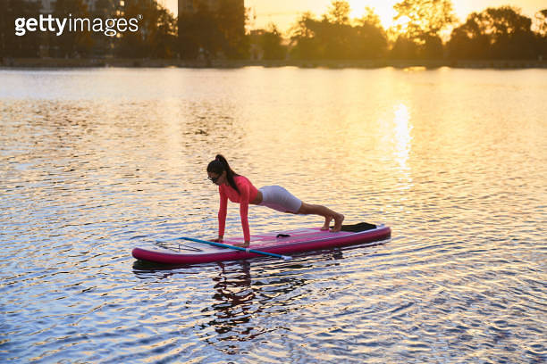 Sporty woman doing plank exercises on paddle board 이미지 (1973244883 ...