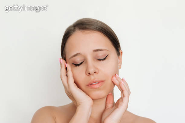 Portrait of a young attractive caucasian woman with makeup touching her ...