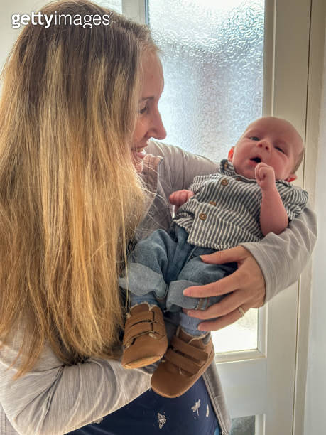 A first time mother proudly holds her new born baby son. This baby has ...