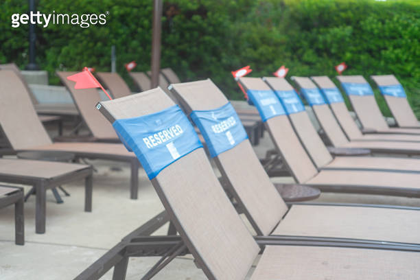 Row of pool lounge chairs with reserved words wrap around and small ...