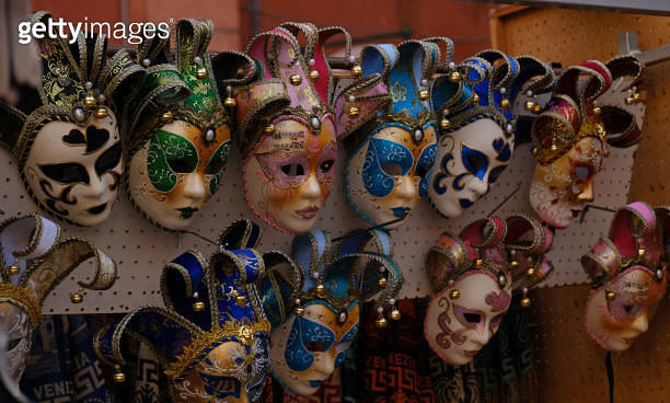 Traditional venetian masks on shelves in souvenirs shop in Venice, Italy. Beautiful carnival ...