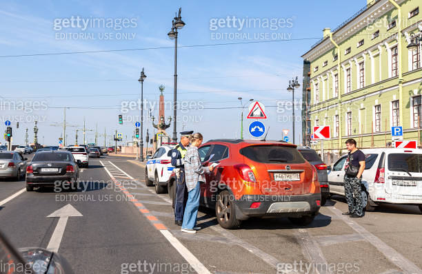 Police officer checks the documents of drivers on a city street ...