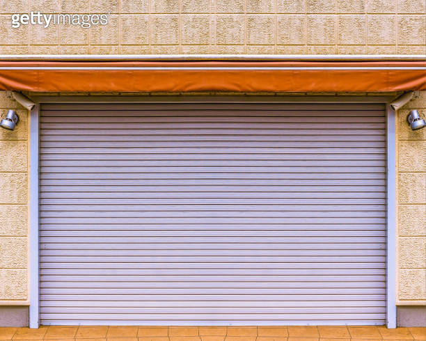 Rusty old closed steel shutter door of warehouse, storage or storefront ...