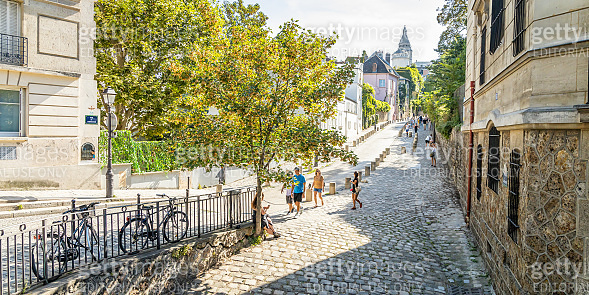 Typical cobblestone street of Montmartre with tourists visiting in ...