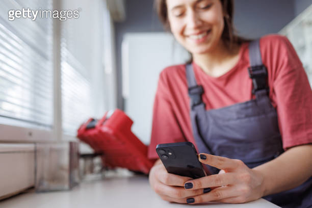 A modern Blue - collar worker using a smart phone 이미지 (1995670680) - 게티 ...