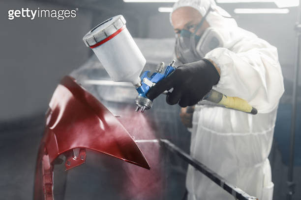 Professional car painting in paint booth, automobile painter sprays ...