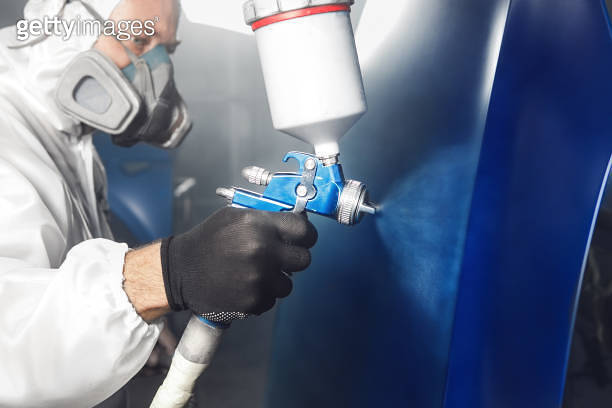 Car repairman artist hand wearing in protective workwear with airbrush ...