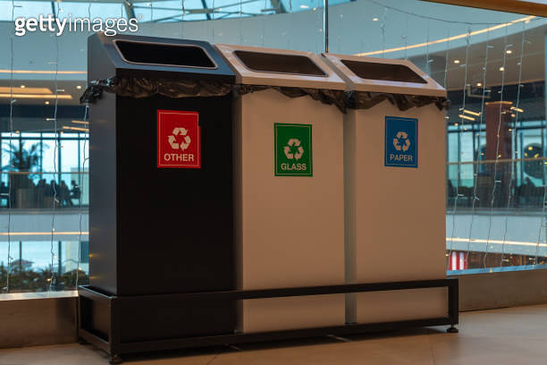Close-up of trash cans for separate dumping of glass, paper and other ...
