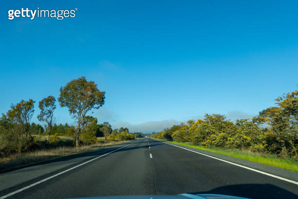 The view through the front window shows an empty motorway under a clear ...