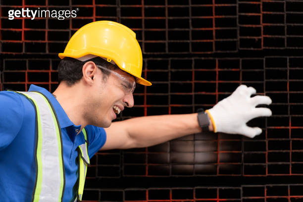 Portrait of a male worker wearing a safety vest and helmet sitting on a ...