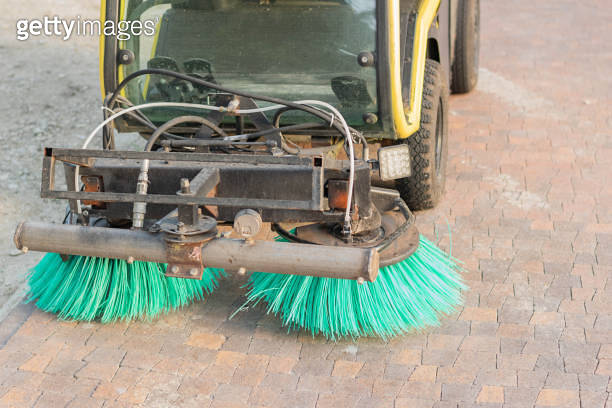 Street Sweeper Machine Cleaning Sidewalk with Rotating Brushes on Brick ...