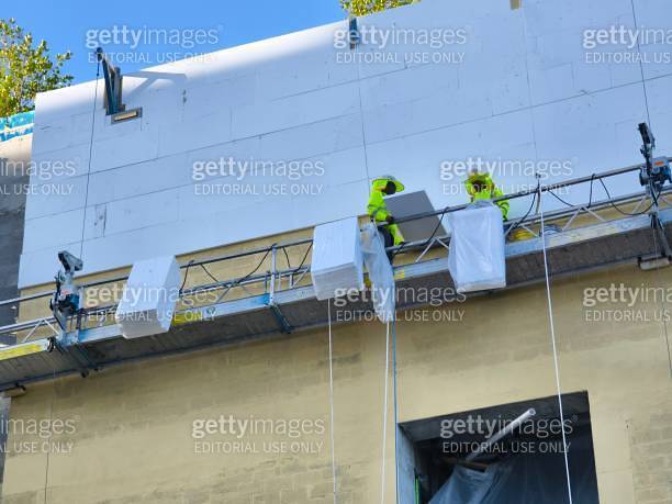 Miami Beach, Florida - Two construction workers clad in bright yellow ...
