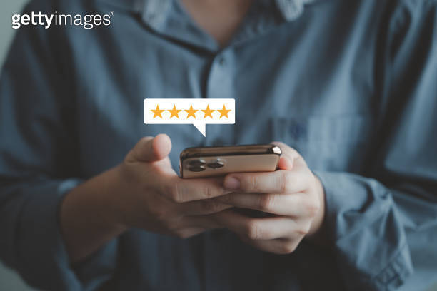 Customer using mobile smartphone for giving satisfaction with five star ...