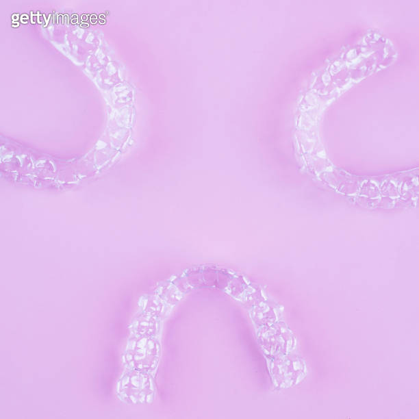 Invisible dental teeth brackets tooth aligners on pink background ...