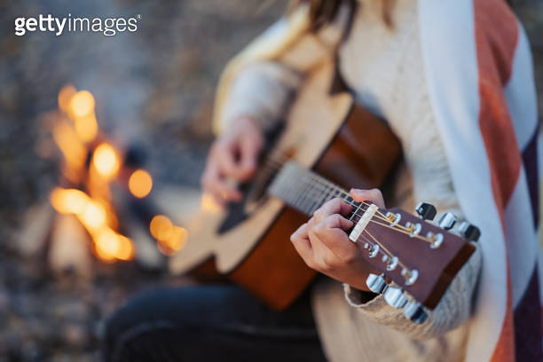 Close up of a girl playing the guitar near bonfire 이미지 (2045329986 ...