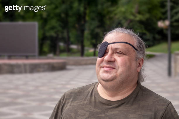 Portrait of a blind, visually impaired man with a black medical bandage ...