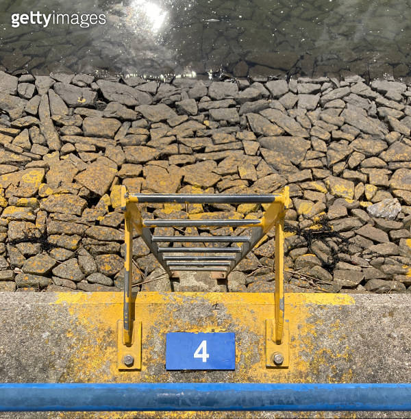 Steel ladder leading down to the water edge - situated on a quayside ...