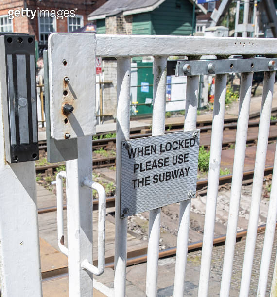 Railway gate, track and platform beyond - safety gate to prevent access ...
