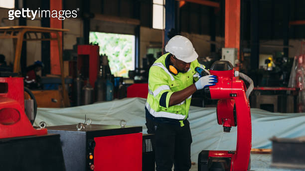 Engineers inspecting and check up machine of the automated arms machine ...