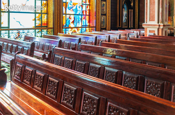 Empty wooden church benches of a Christian church. Blurry alter in the ...