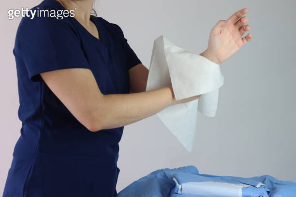 Health care professional drying tha hands and arms with sterile tissue ...
